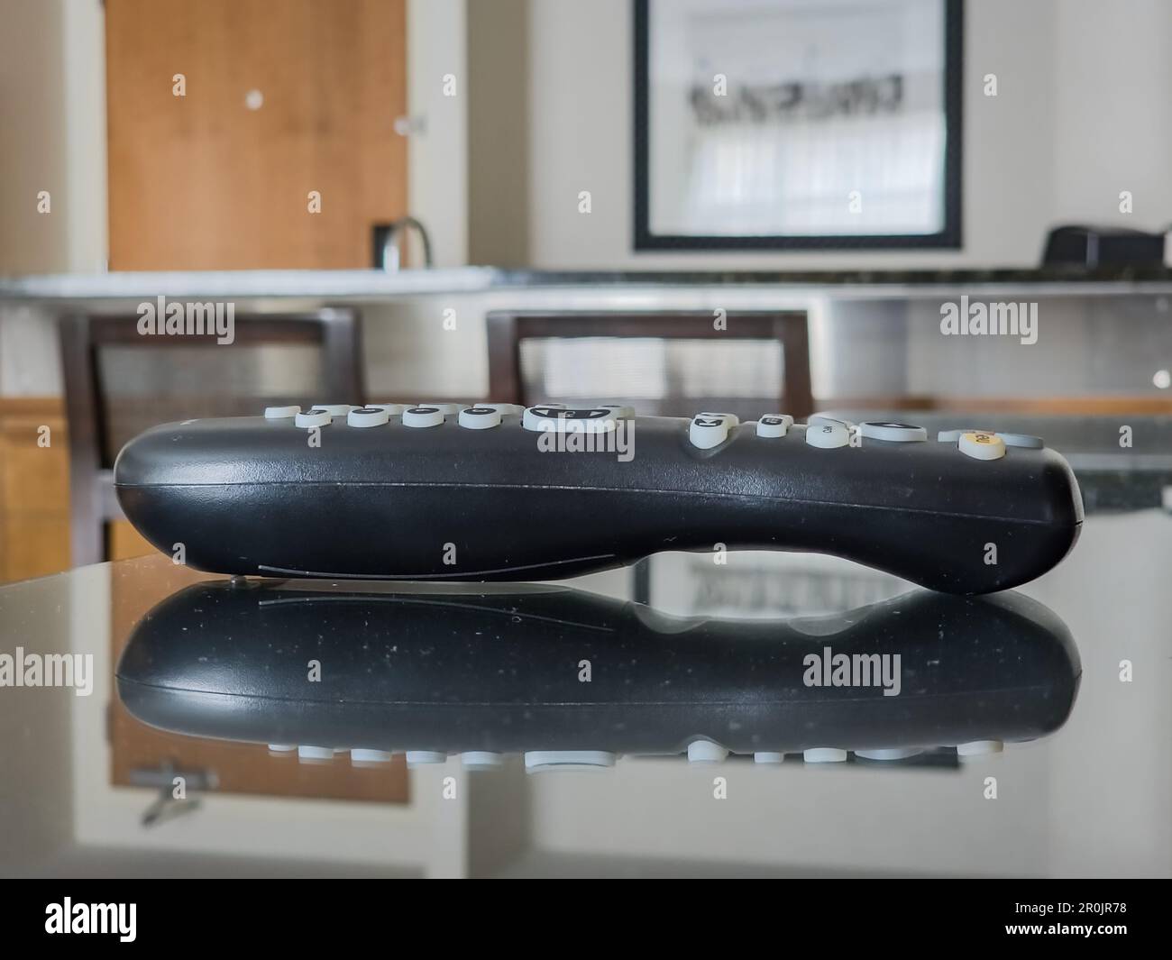 Black remote control reflecting on a mirror table in a hotel room Stock ...