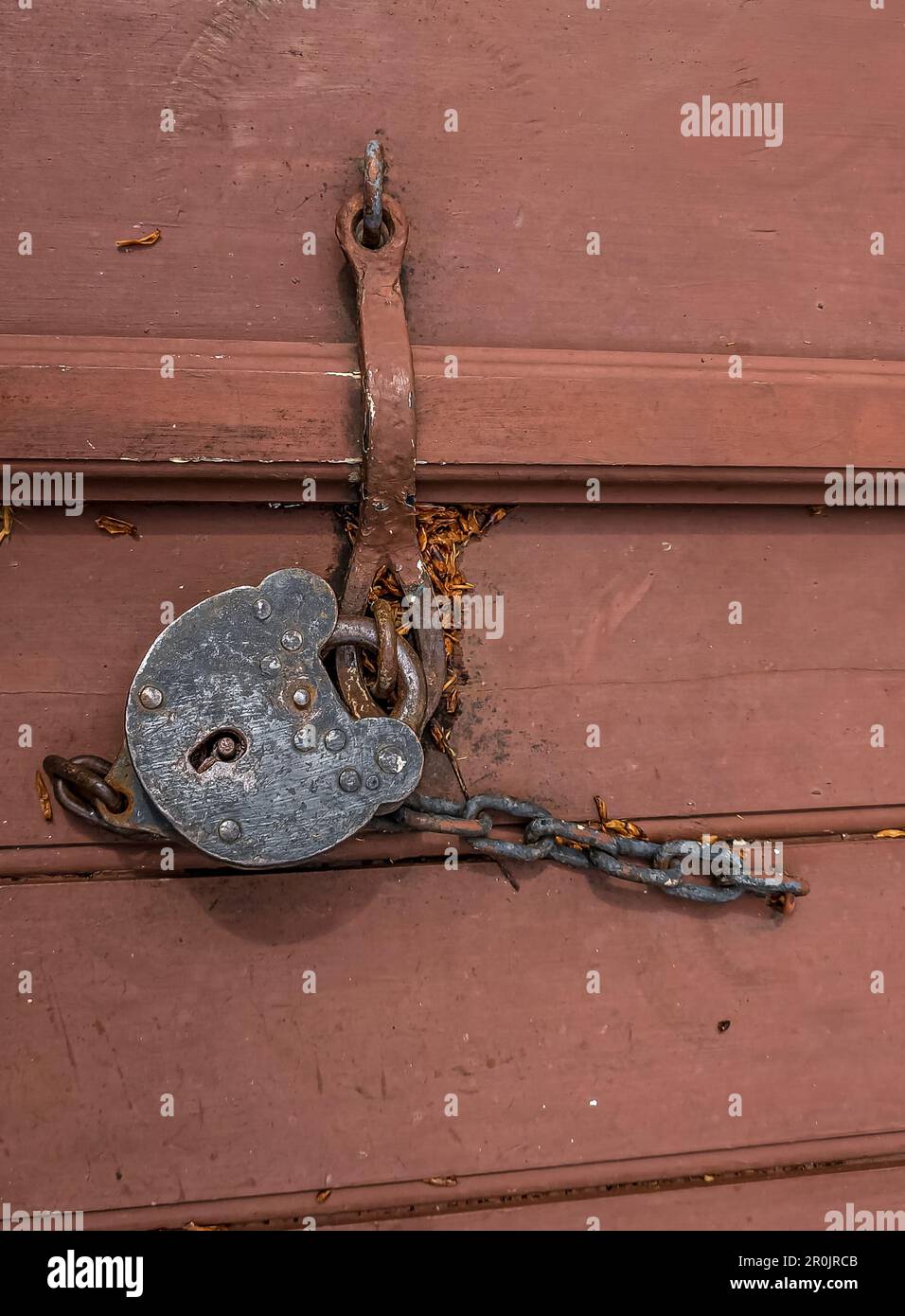 Rustic metal lock with chain on a red wooden door Stock Photo - Alamy