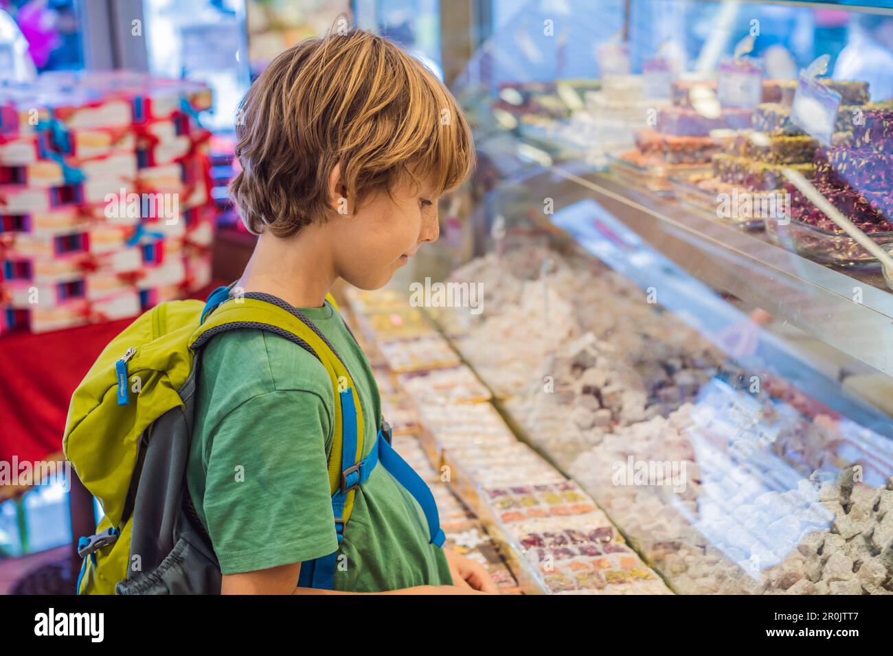 The boy looks at the counter with Turkish sweets. Traditional oriental ...