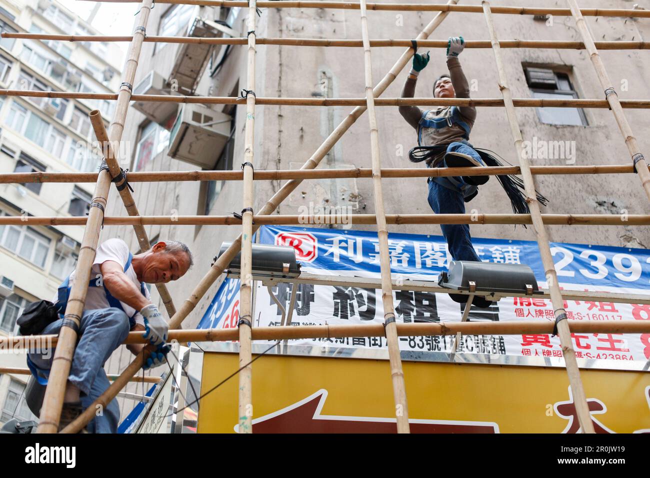 Construction workers on a bamboo scaffold, contruction site, Chinese characters, Causeway Bay ...