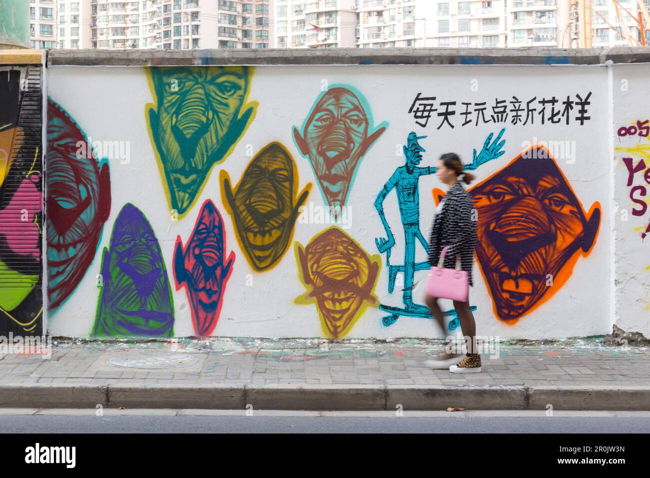 Funny graffiti on wall on Moganshan Road, women passing, street art ...