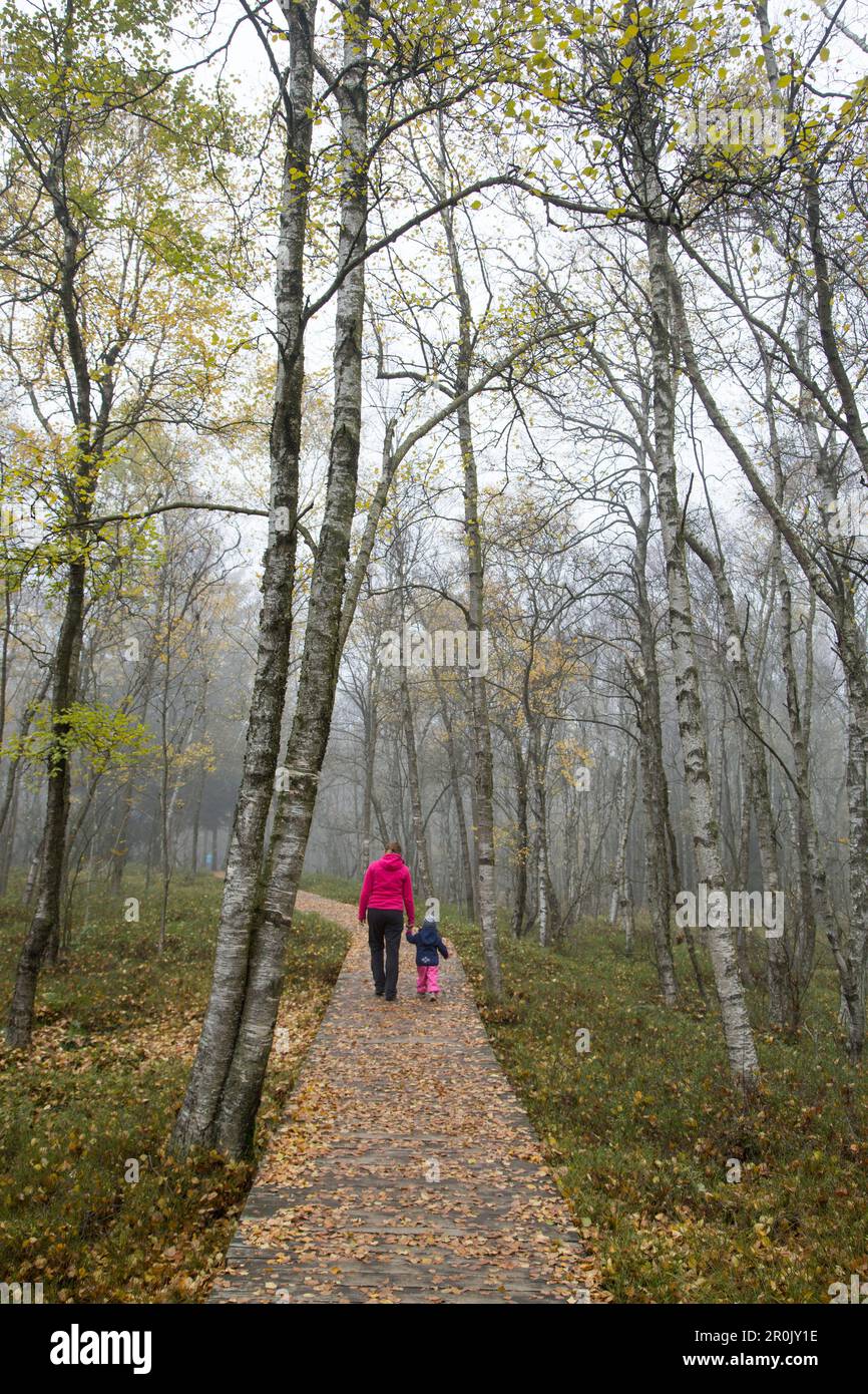 Mother and daughter walk along boardwalk through Red Moor (Rotes Moor ...