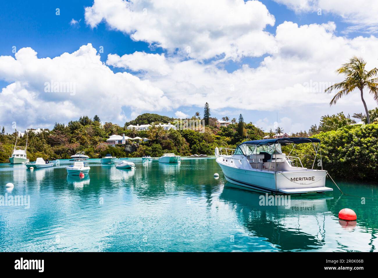 View at private motorboats in clear blue water with villas and palm ...