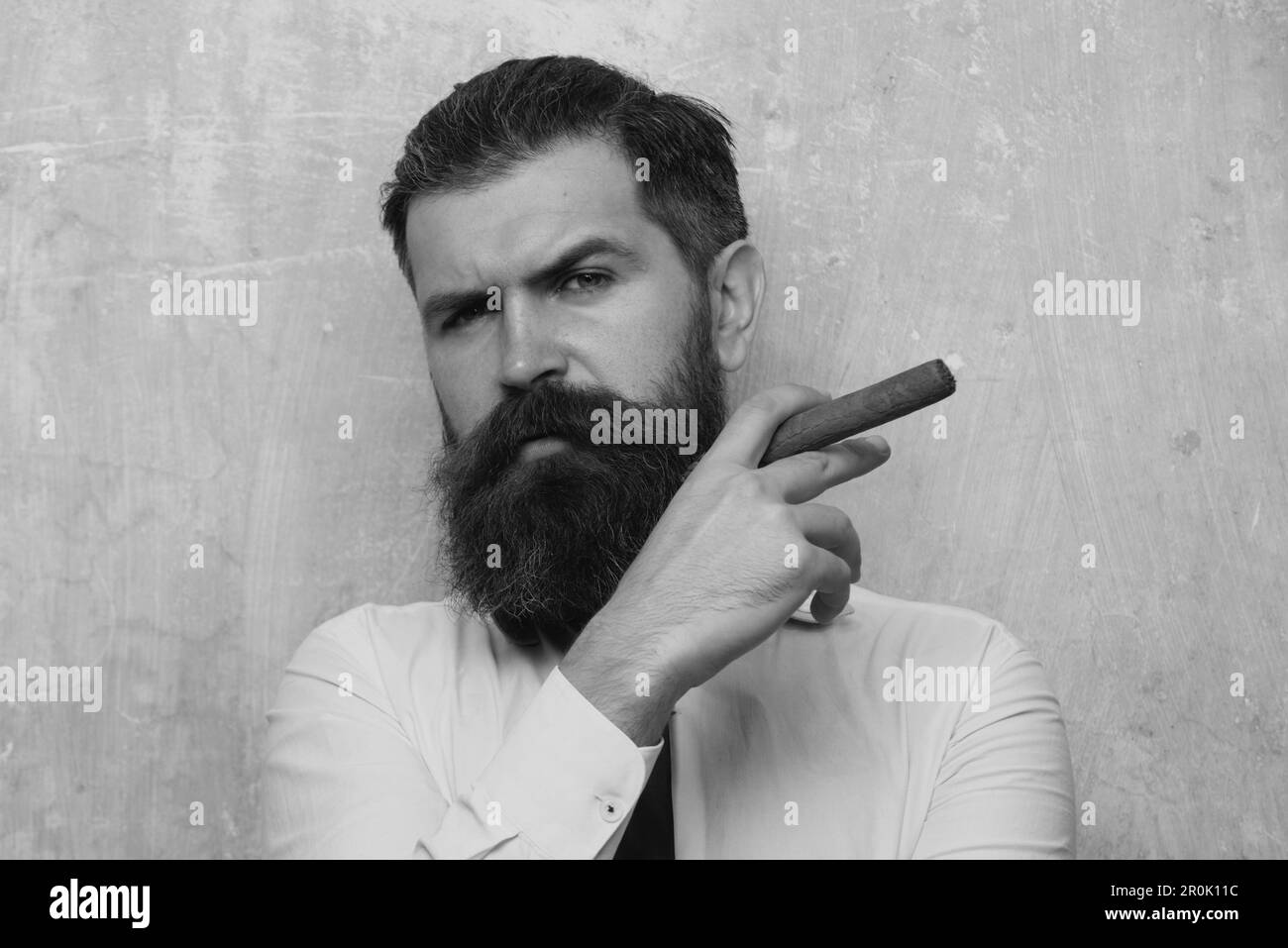 Brutal man smoking cigar, handsome serious male model Stock Photo - Alamy