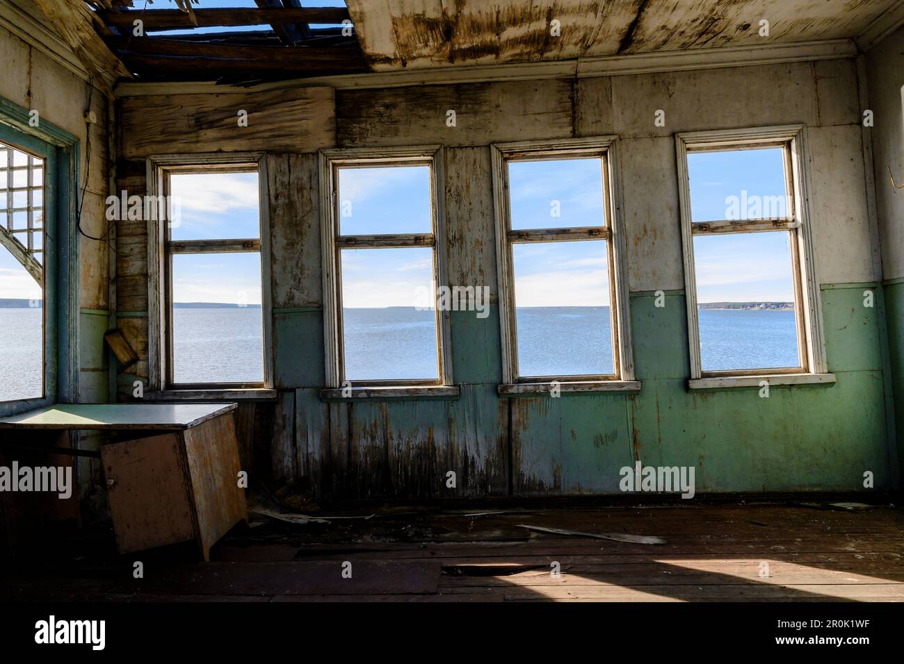 A room of an abandoned wooden house with empty windows without glass ...