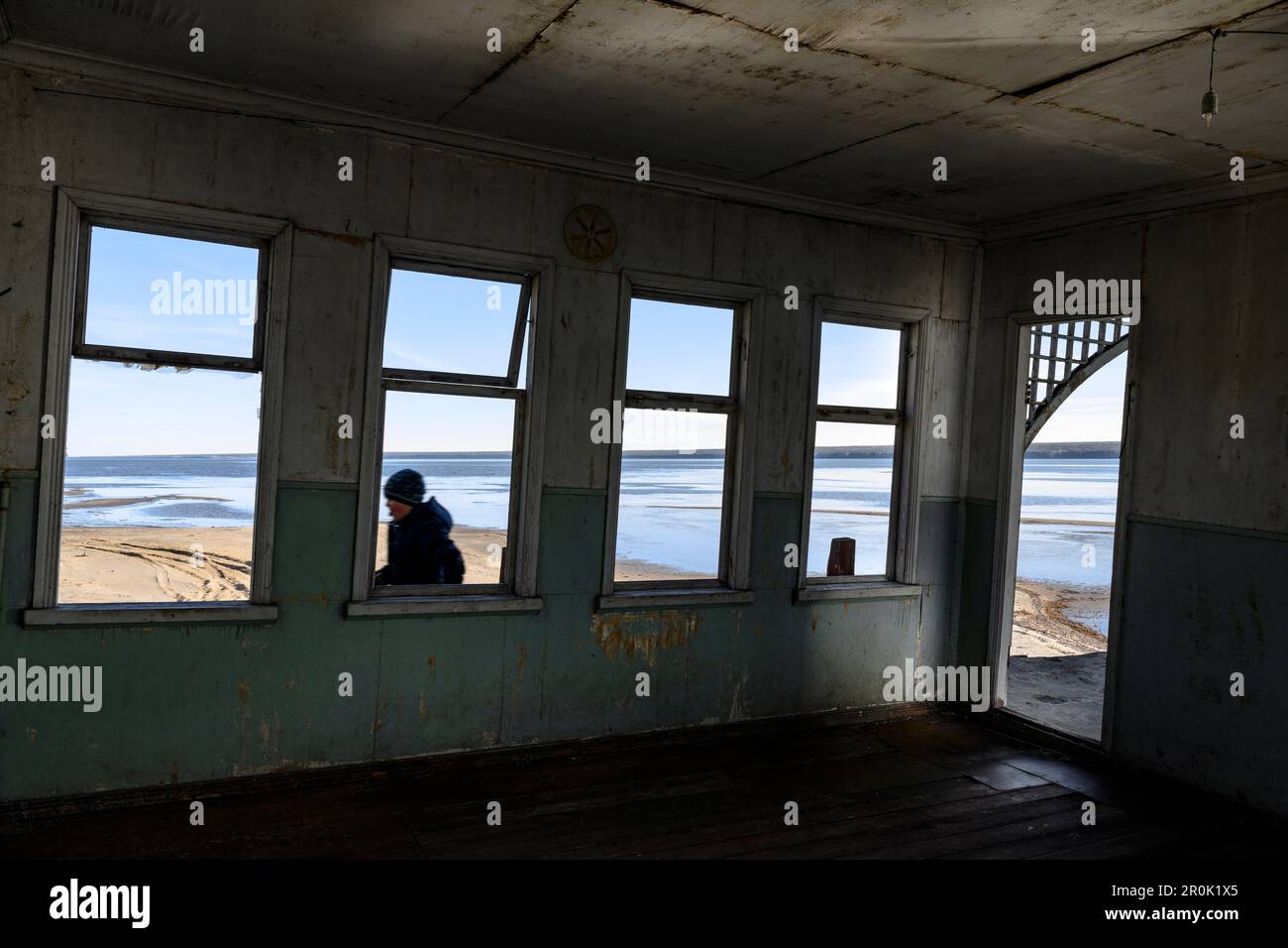 A room of an abandoned wooden house with empty windows without glass ...