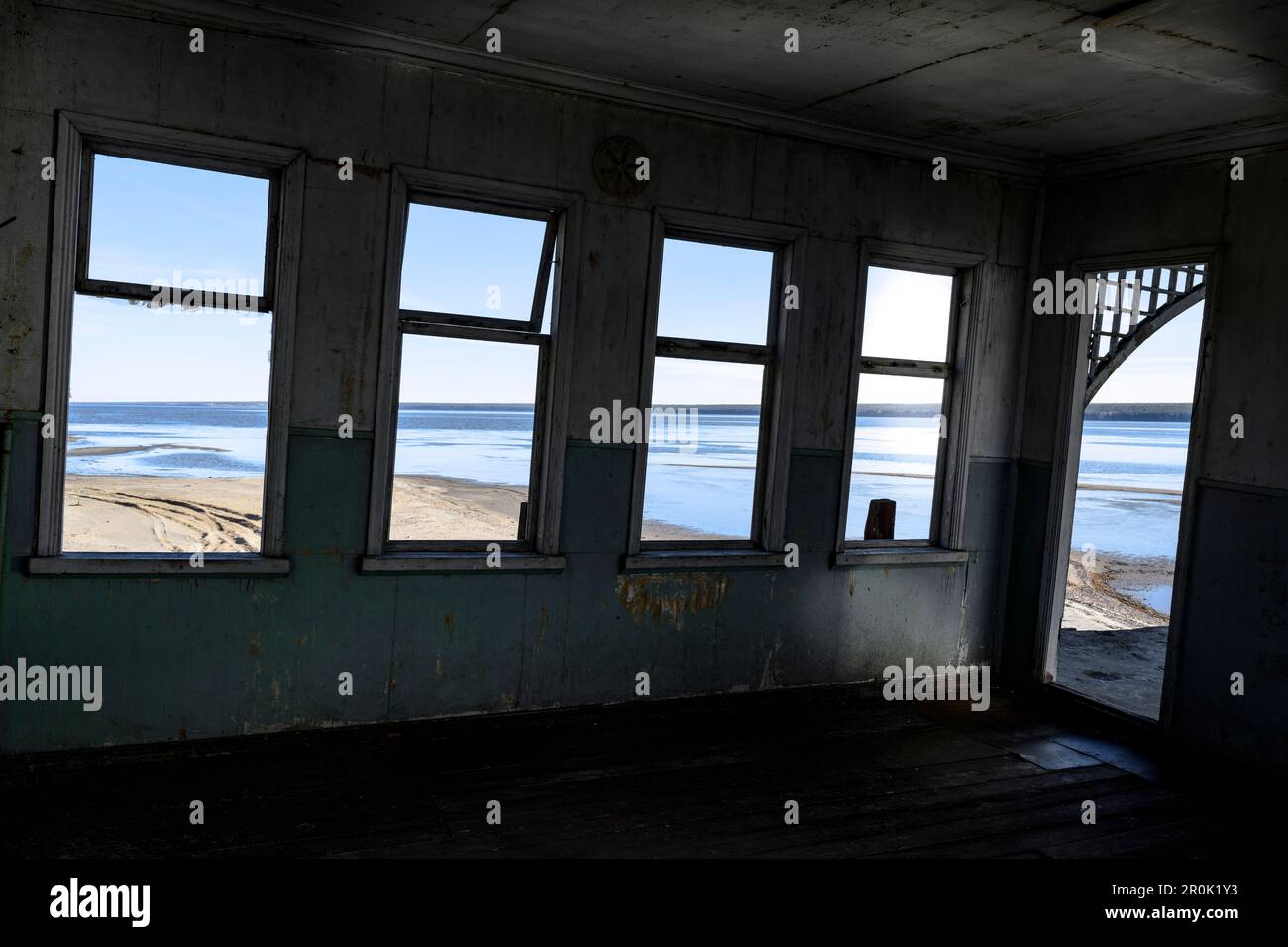 A room of an abandoned wooden house with empty windows without glass ...