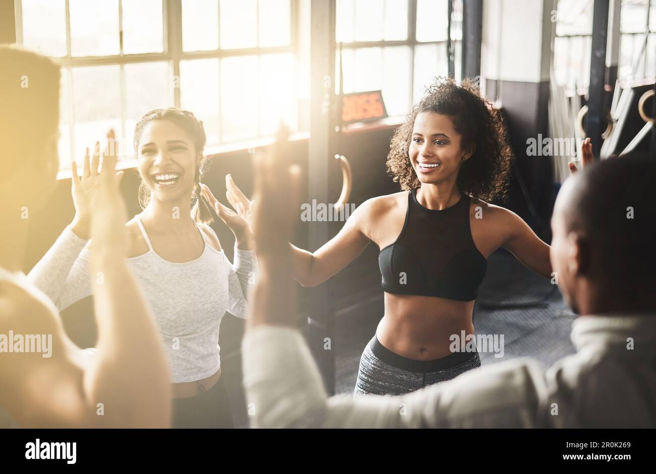 High five, funny and teamwork of friends in gym for fitness, team building and solidarity ...
