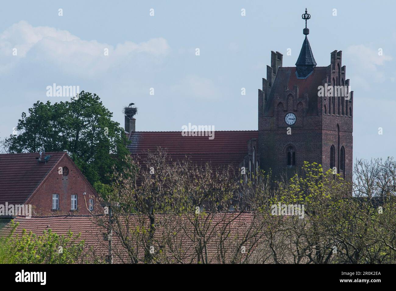 Gothic village church, church tower with stork in birds nest ...