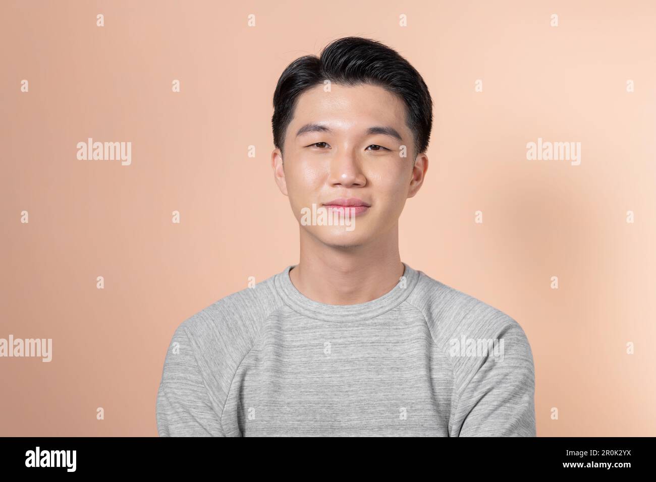Close up portrait of young handsome Asian man face on beige studio ...