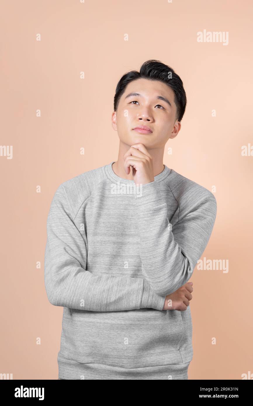 Happy smiling young handsome Asian man face with hand touching chin Stock Photo - Alamy