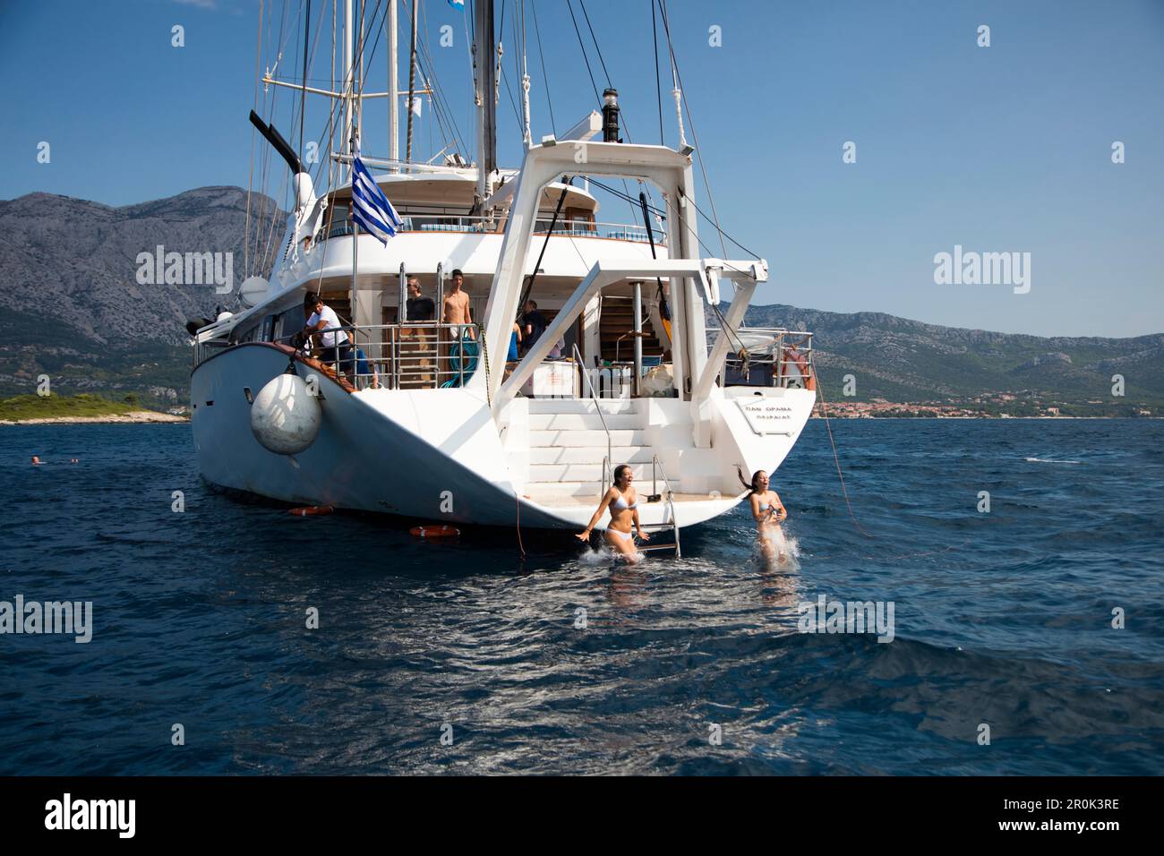 Two young women jump from deck platform of motor sailing cruise ship M ...