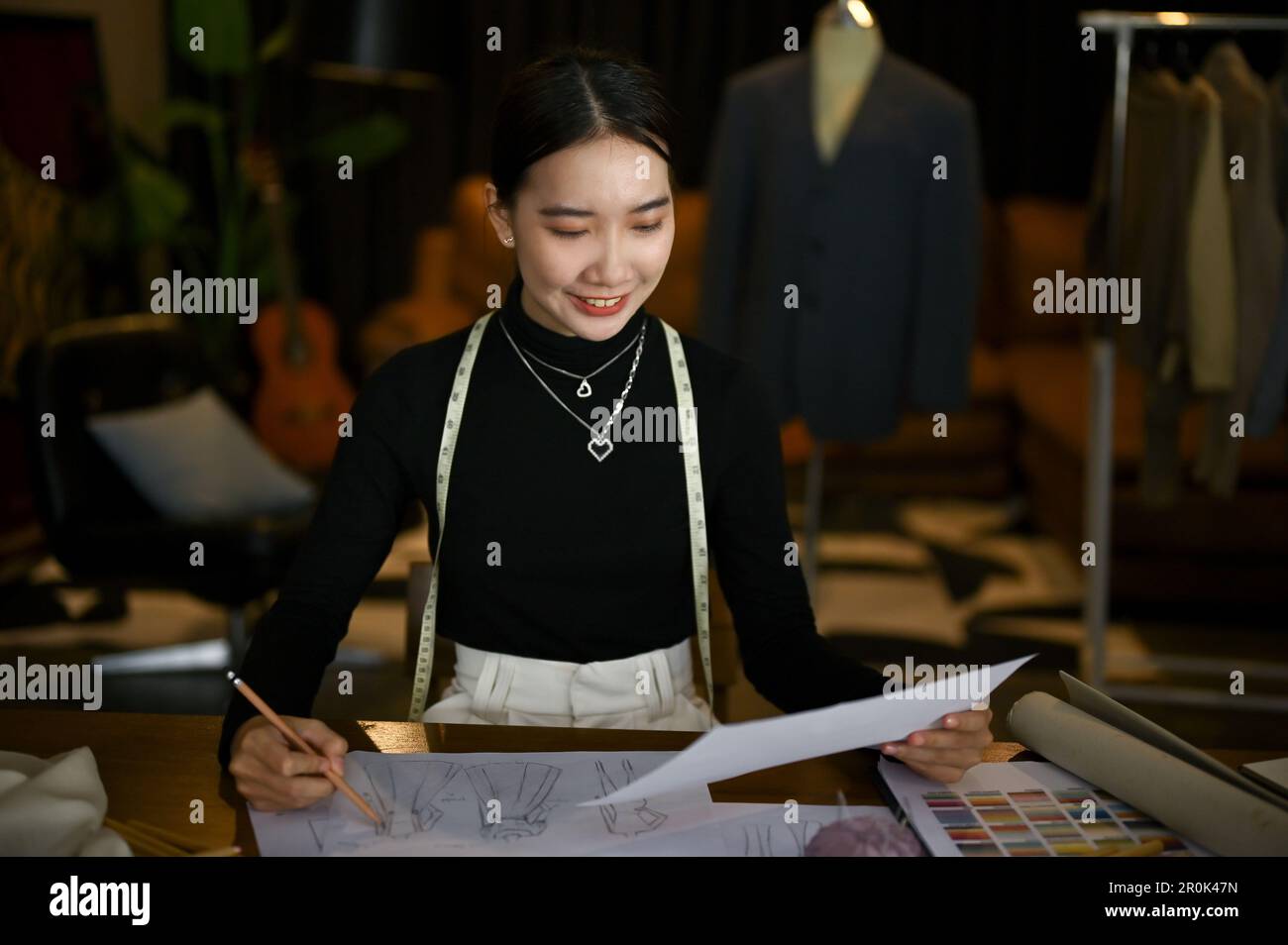 Happy and professional millennial Asian female fashion designer ...