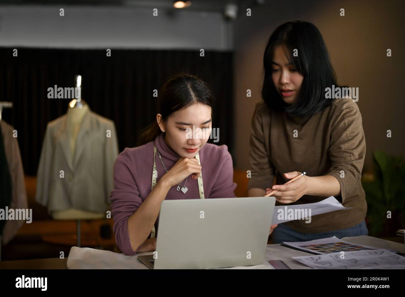 A focused and professional millennial Asian female dressmaker or ...