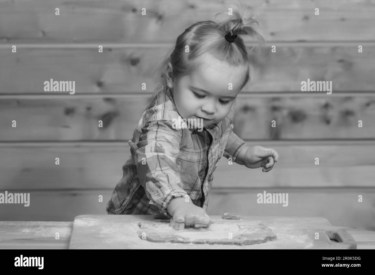 Baby child boy in the kitchen helping with cooking, playing with flour ...