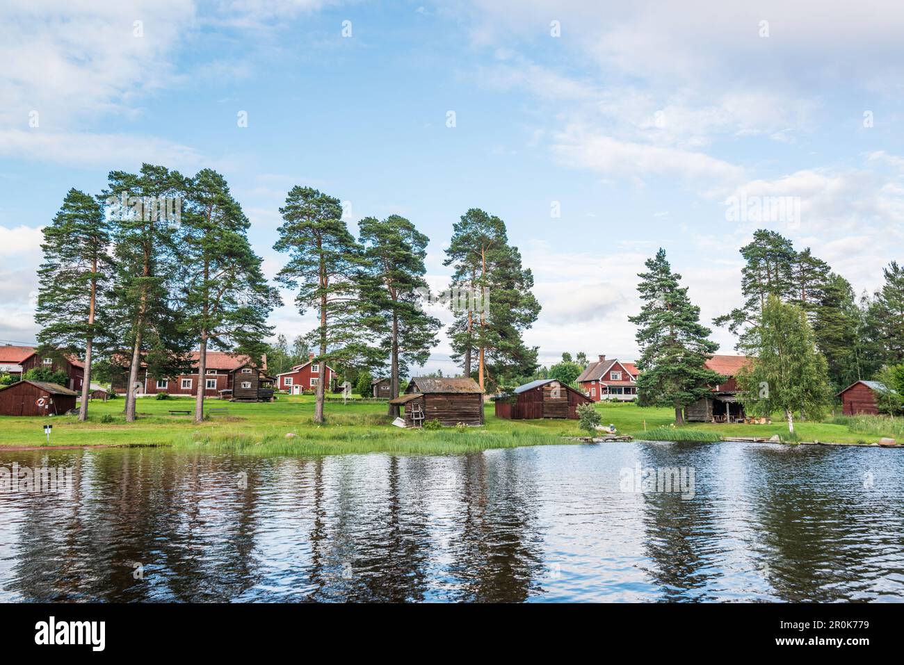 view from water to the village of Bodarna with its red wooden houses ...