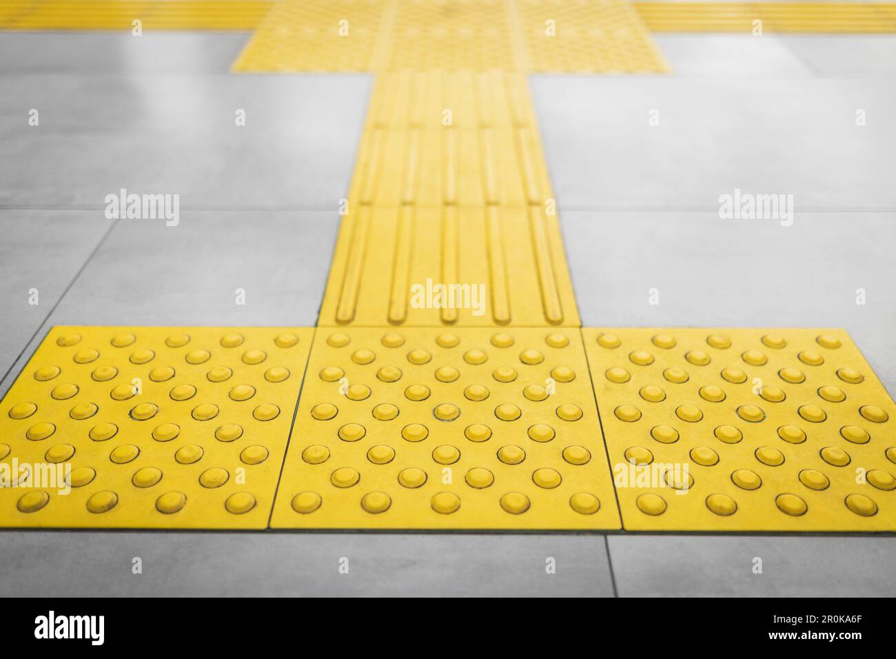 Top view of yellow tactile tiles for the blind stacked on gray tiled ...