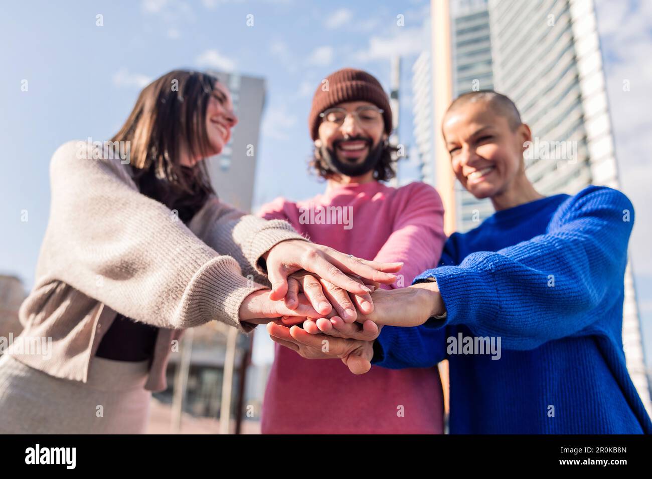 three smiling friends holding hands in friendship Stock Photo - Alamy