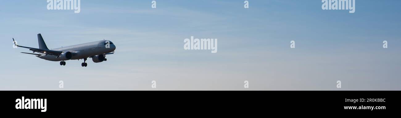 Side view of an airplane landing against a blue sky. Widescreen Stock ...