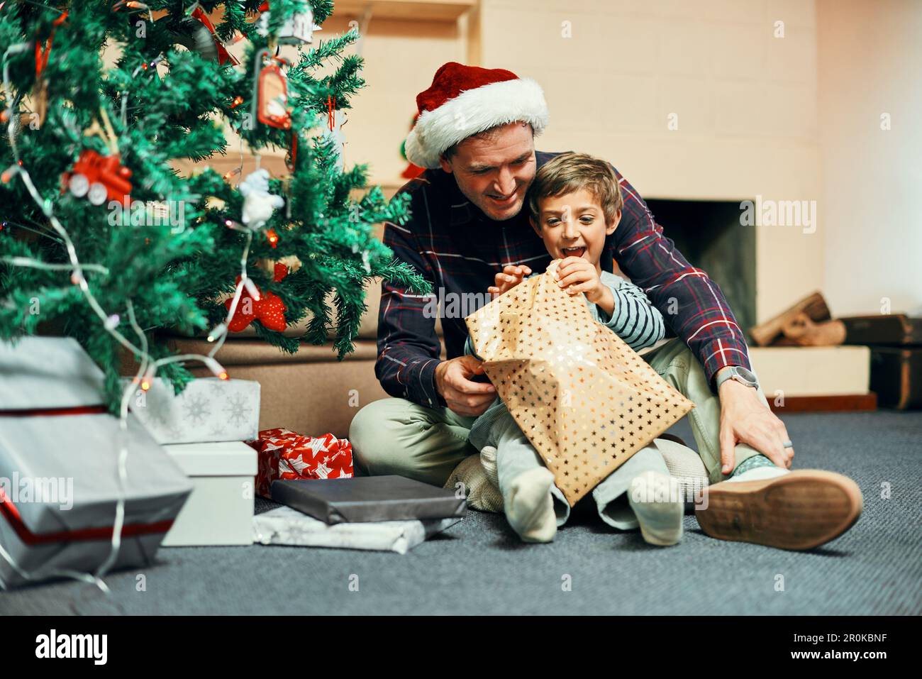 Woah I wonder what it is. an adorable little boy unwrapping Christmas ...