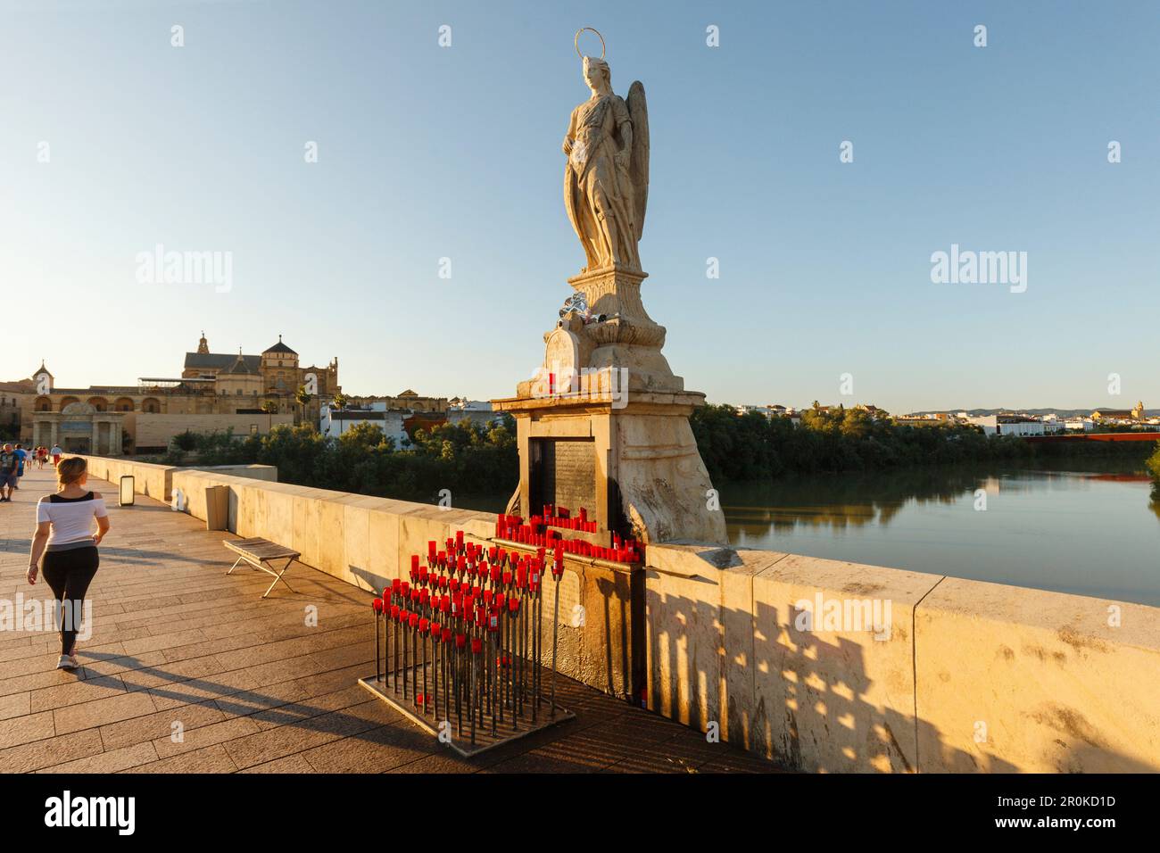 women walking past the sculpture of angel St Raphael, patron saint of ...