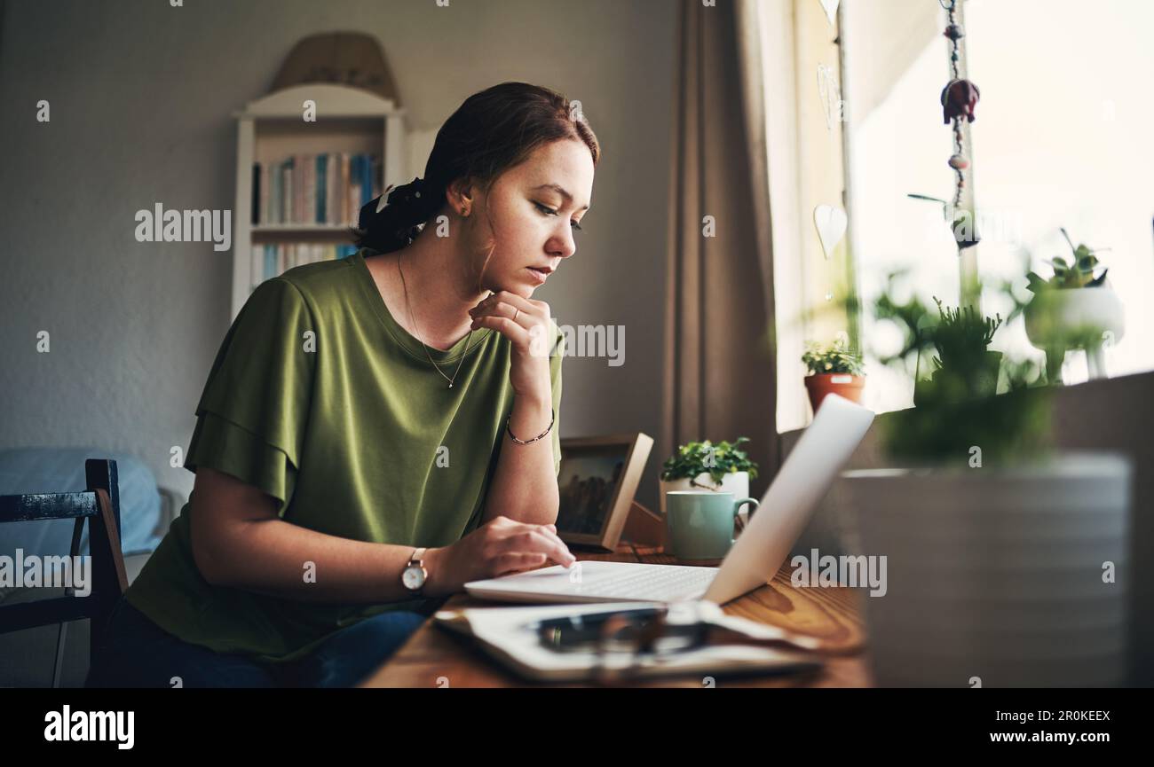 Staying at home, slaying those goals. a young woman using a laptop ...