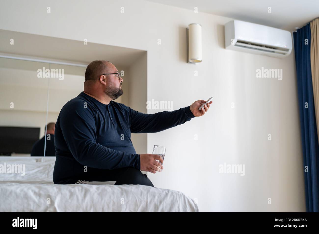 Frustrated overweight man suffer from heat hold glass of water includes ...