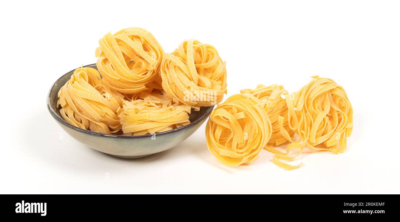 Tagliatelle pasta rolls on a white background Stock Photo - Alamy