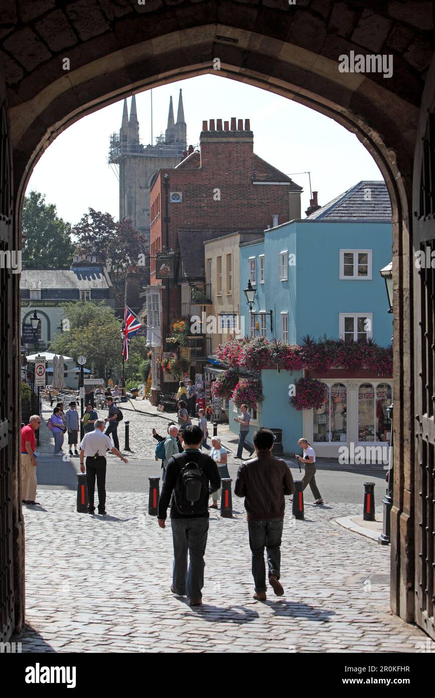 View through the entrance gate of WIndsor Castle and colorful houses of ...