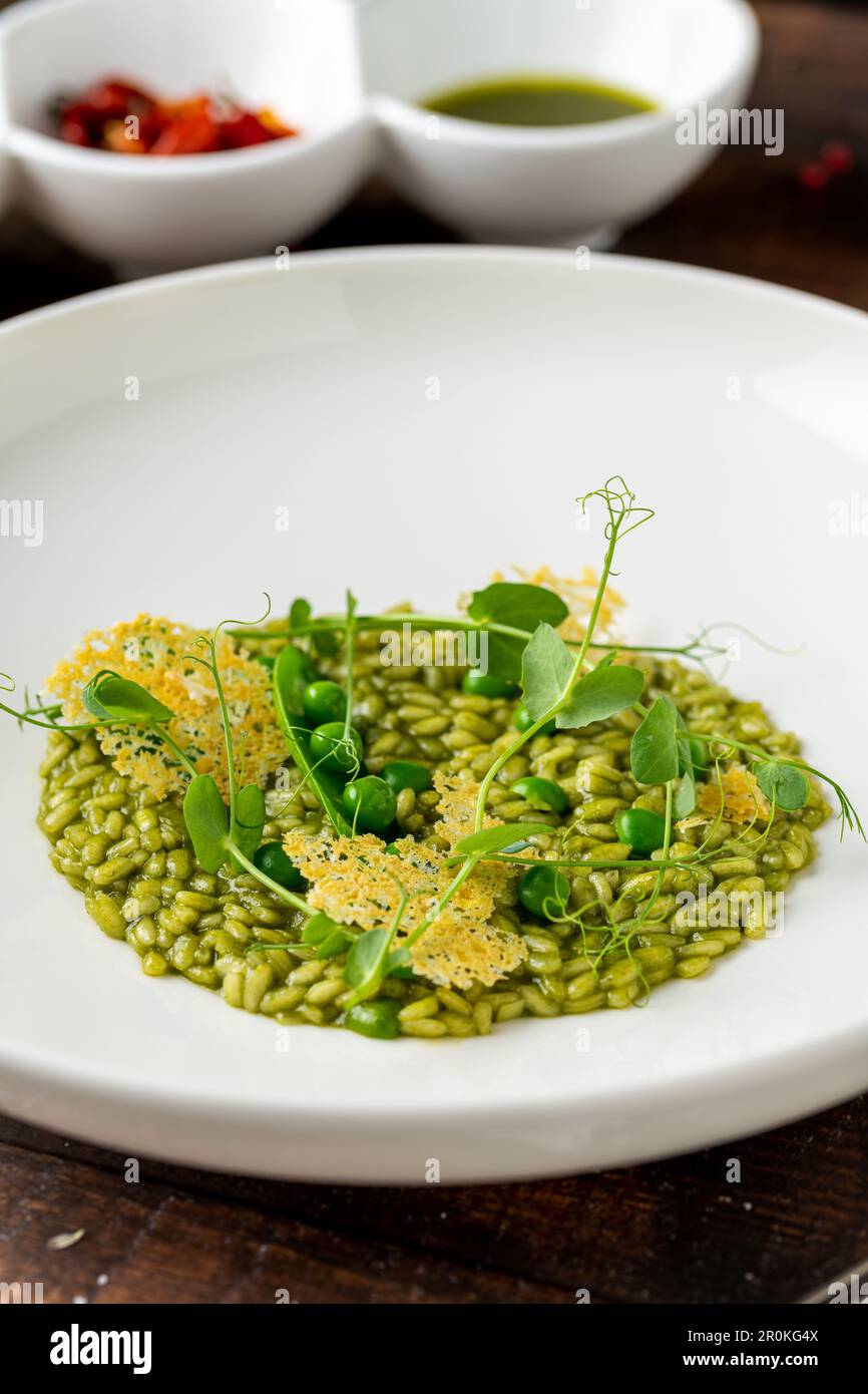 Pea risotto on a white porcelain plate in a fine dining restaurant ...