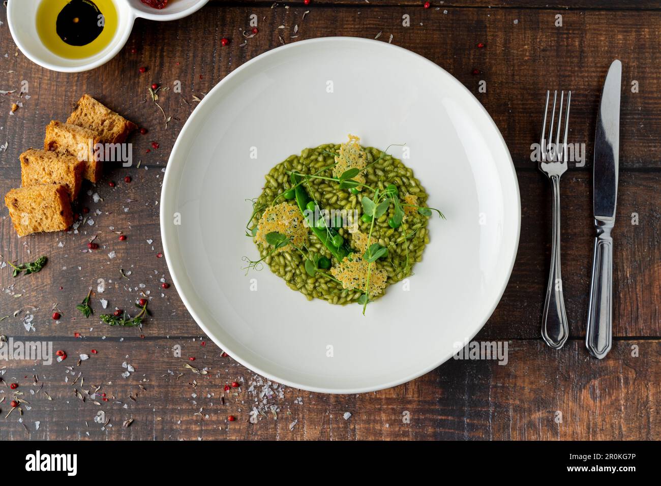 Pea risotto on a white porcelain plate in a fine dining restaurant ...