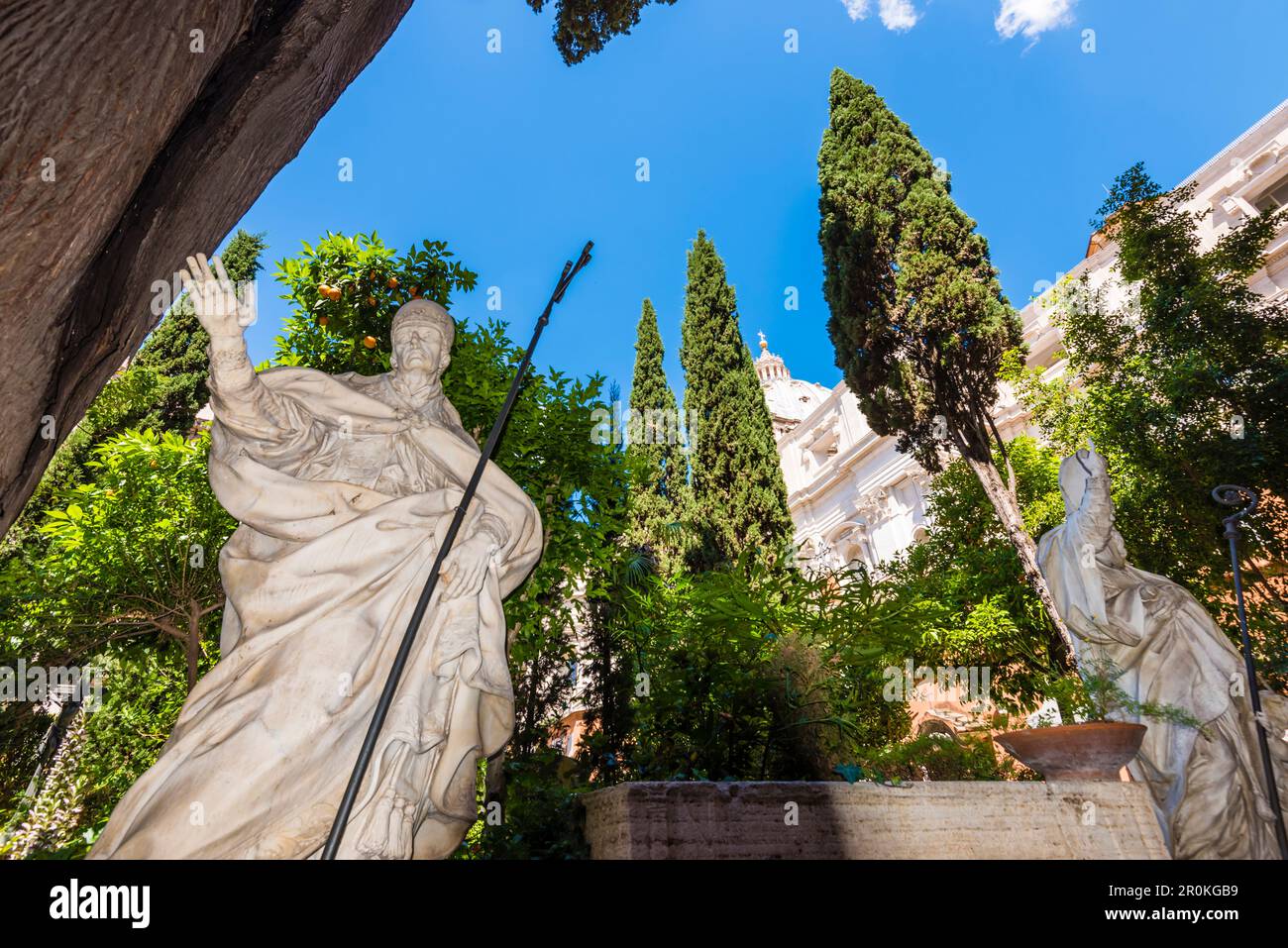 Statues on the cemetery of Campo Santo Teutonico with the dome of St ...