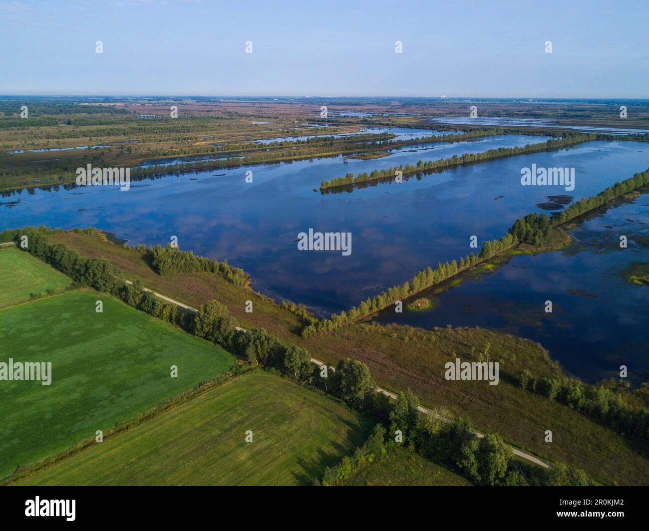 Aerial of people cycling along lakes and peat bog lands through ...