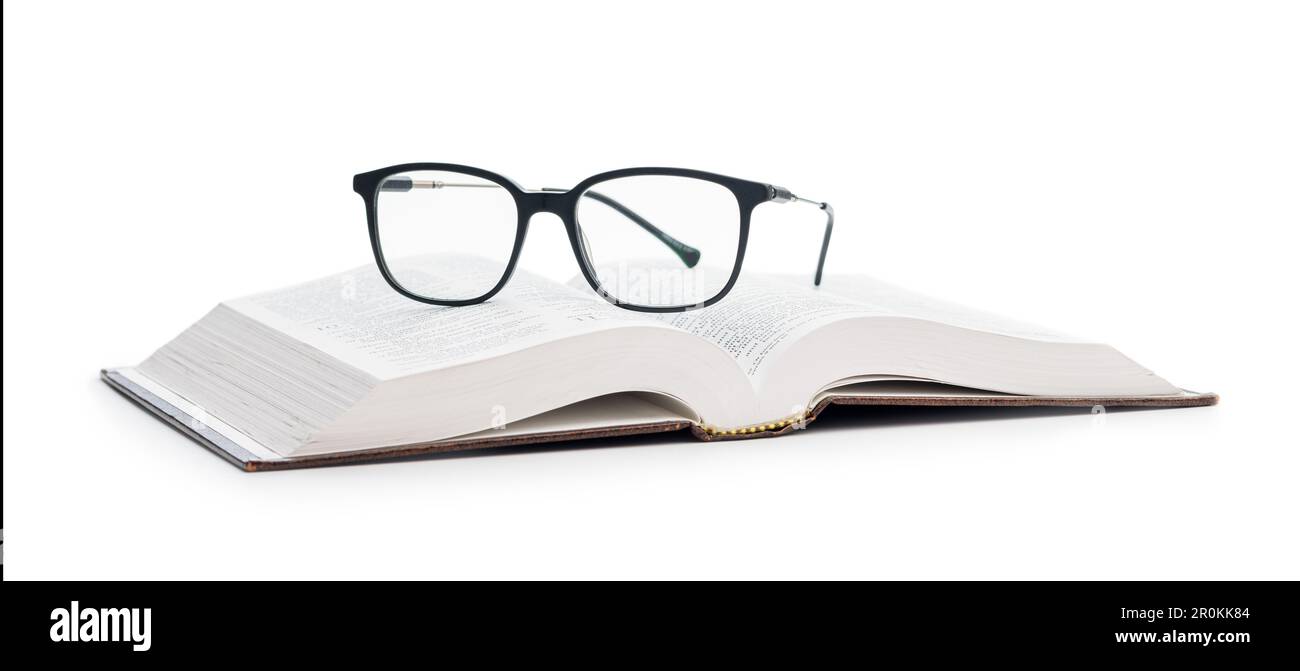 The reading glasses on opened book isolated on the white background ...