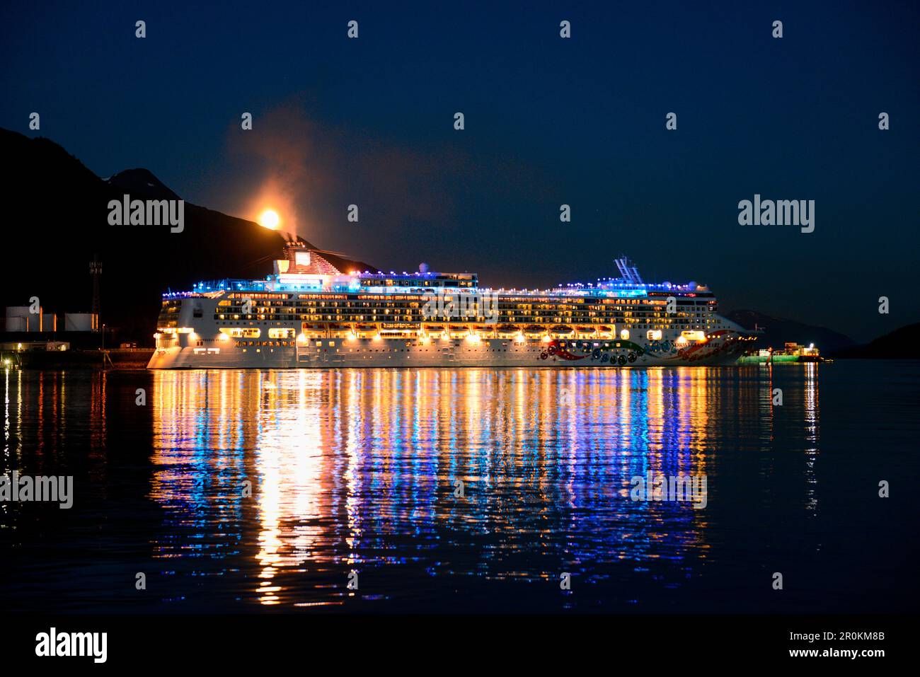 Full moon rises over mountains behind illuminated cruise ship Norwegian ...