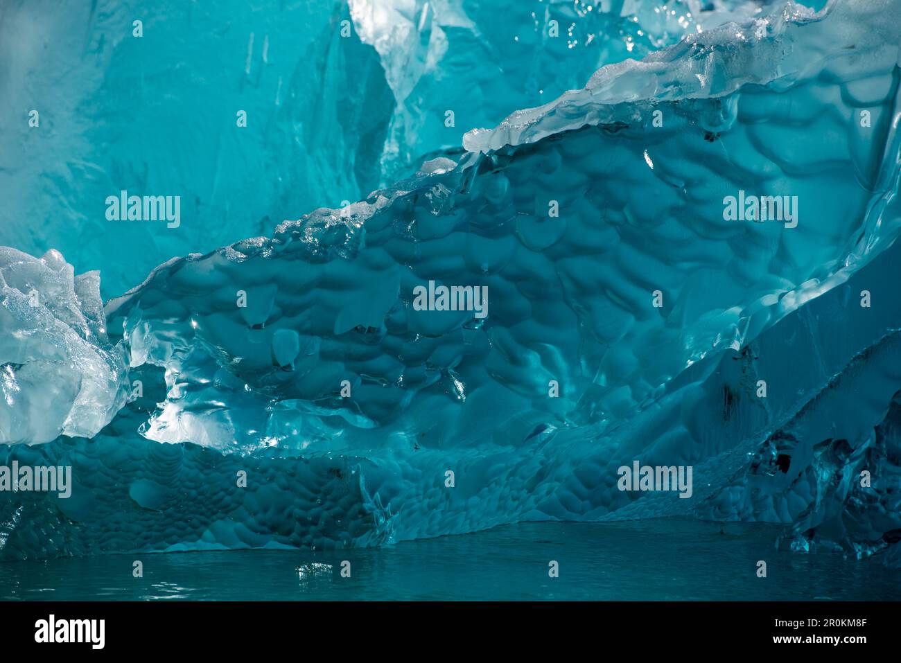 Detail of a large iceberg of translucent ice floating in front of the ...