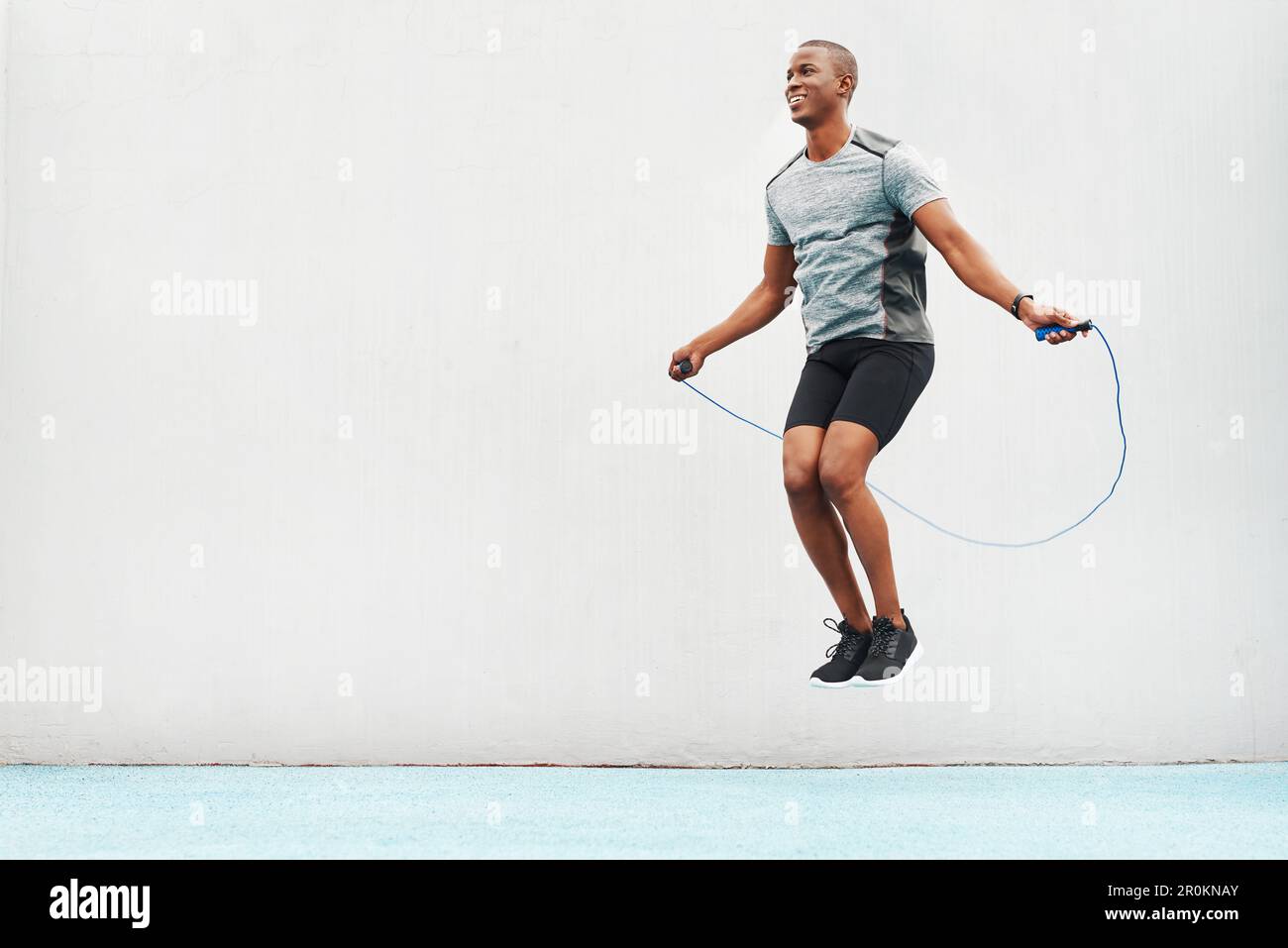 Train like a beast. Full length shot of a handsome young athlete using ...