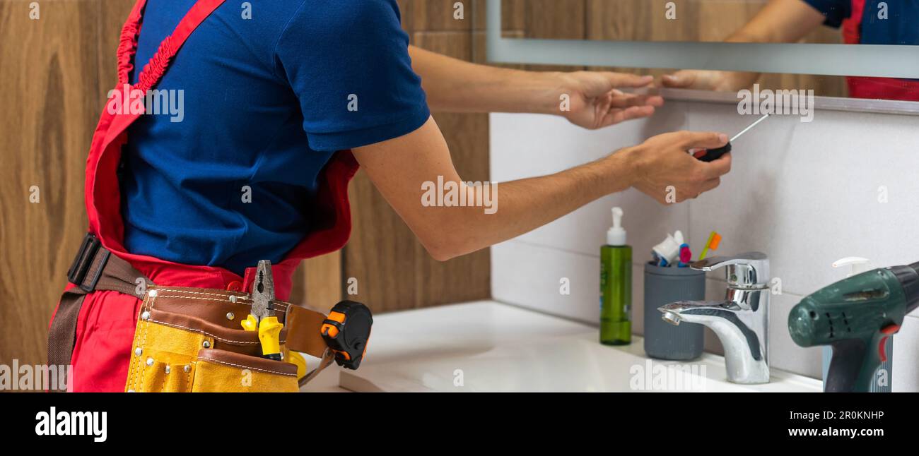 the man fixes the mirror Stock Photo - Alamy
