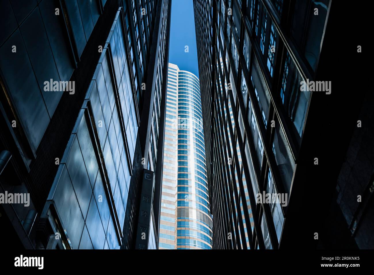View from a narrow dark skyscraper canyon to a high-rise building in ...