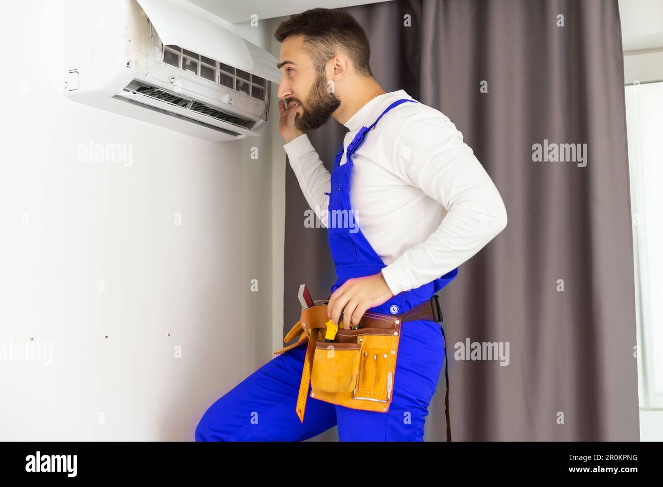 Male technician repairing air conditioner indoors Stock Photo - Alamy