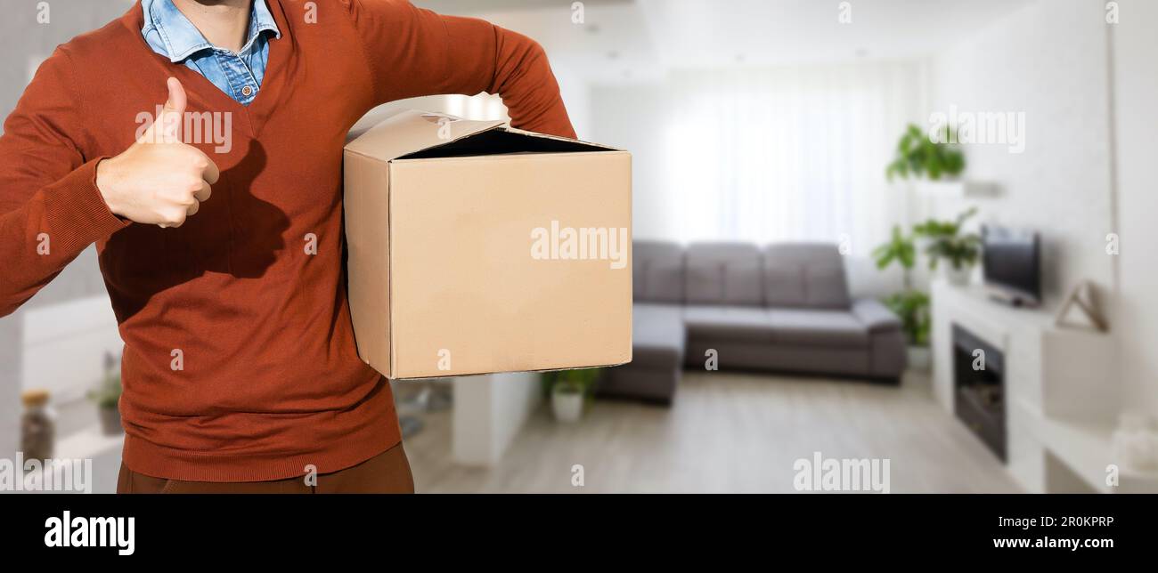 young delivery man standing with parcel post box Stock Photo - Alamy