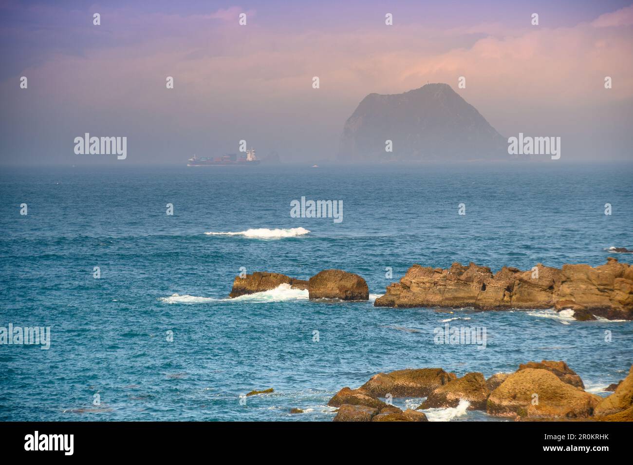 A small island shrouded in mist, blue sea and blue sky. View of Keelung ...
