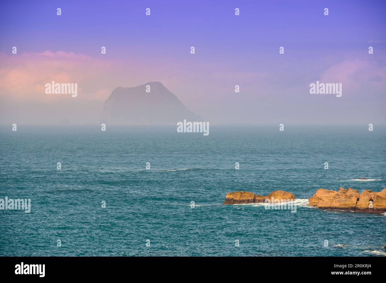 A small island shrouded in mist, blue sea and blue sky. View of Keelung ...