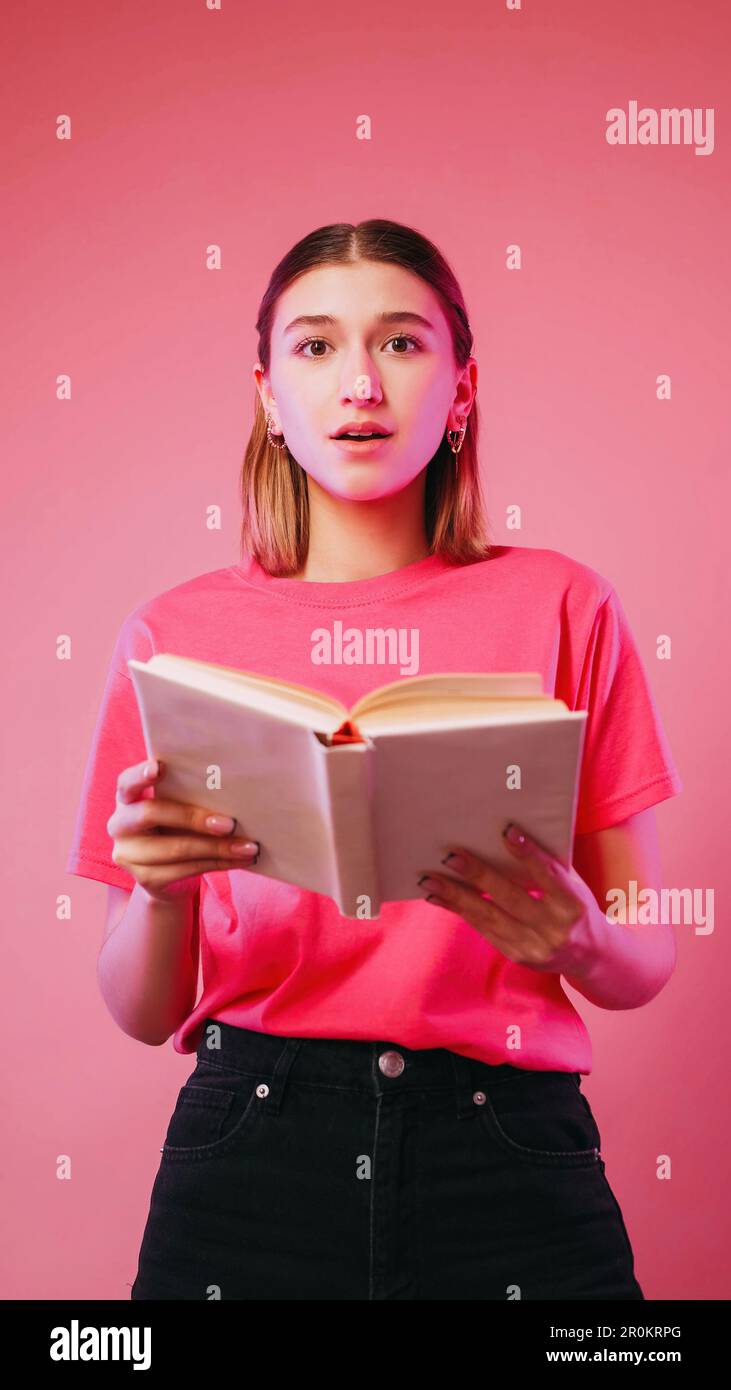 Surprised novel interesting reading girl hold book Stock Photo - Alamy