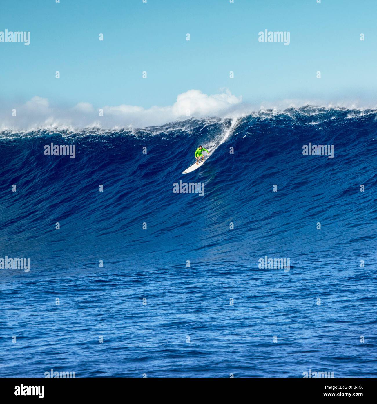 USA, HAWAII, Maui, Jaws, big wave surfers taking off on a wave at Peahi ...