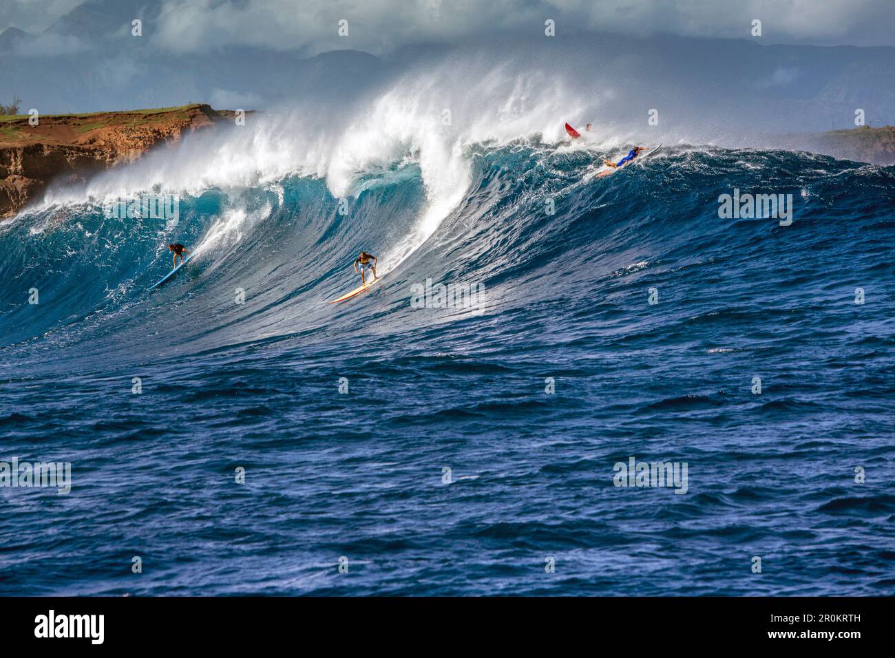 USA, HAWAII, Maui, Jaws, big wave surfers taking off on a wave at Peahi ...