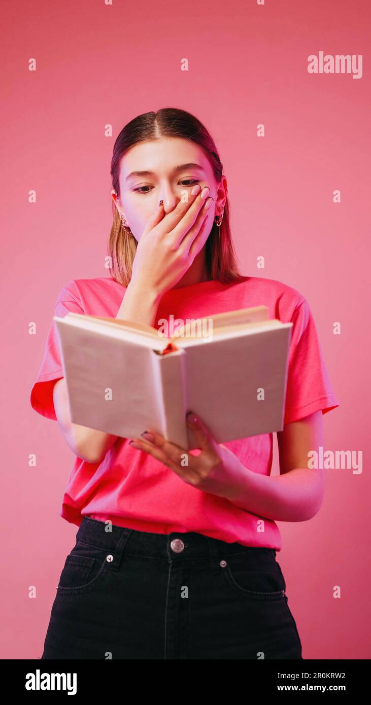 Surprising reading shocked literature excited girl Stock Photo - Alamy