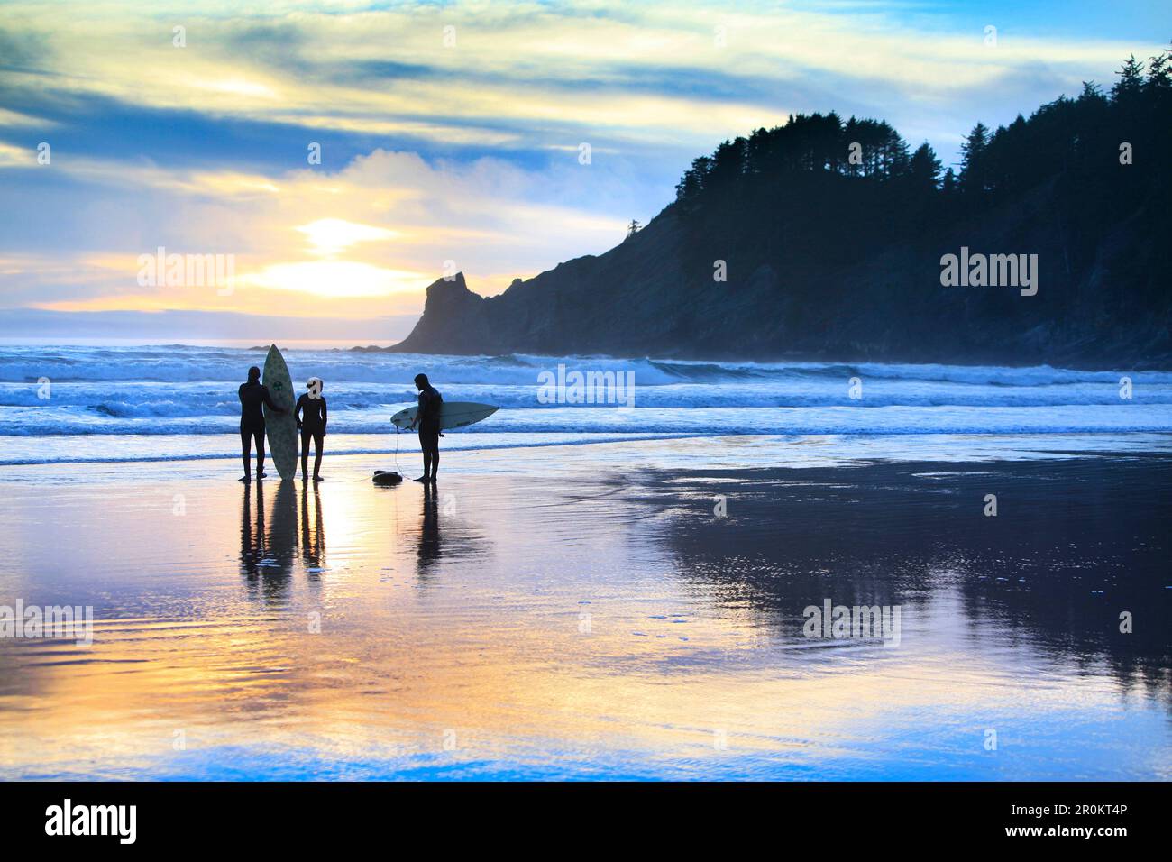 USA, Oregon, Oswald West State Park, surfers walk along the beach and ...