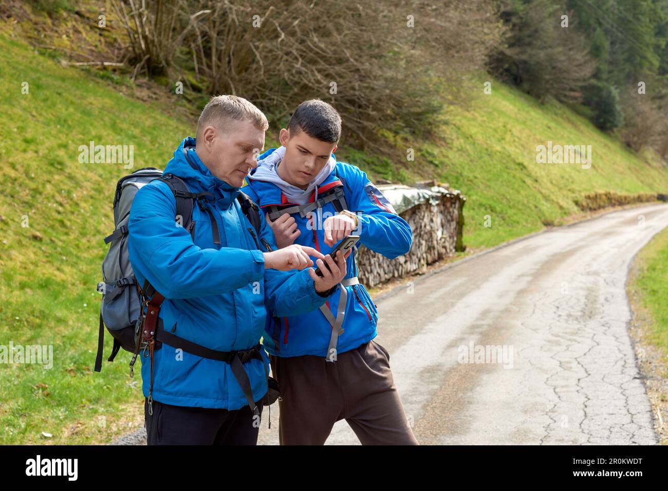 Two hikers are in the mountains in the spring nature outdoor. Hiking ...