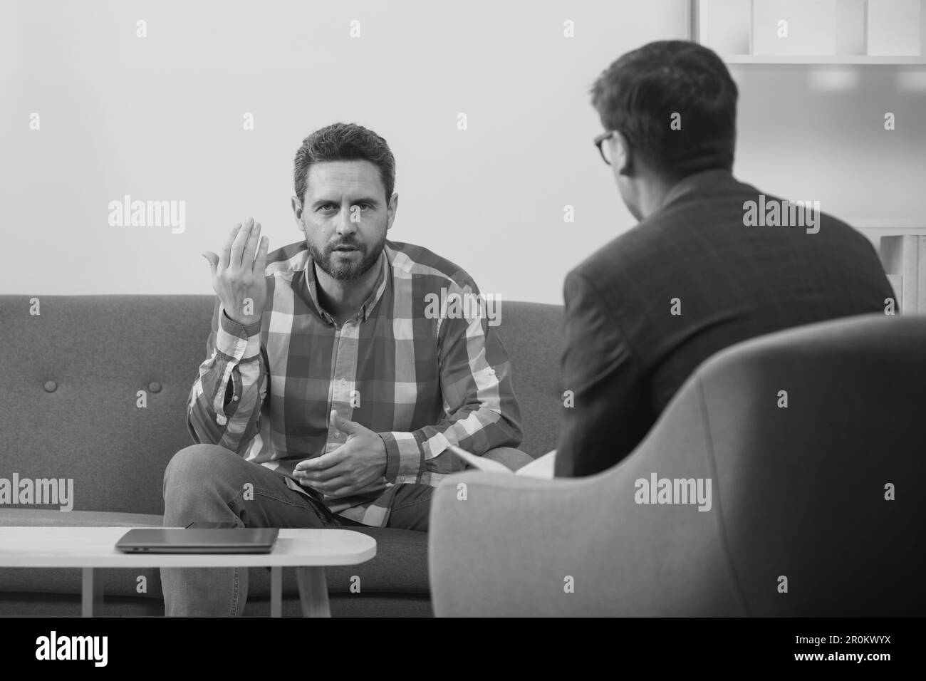 Man discussing his psychological problems with a psychiatrist during a ...